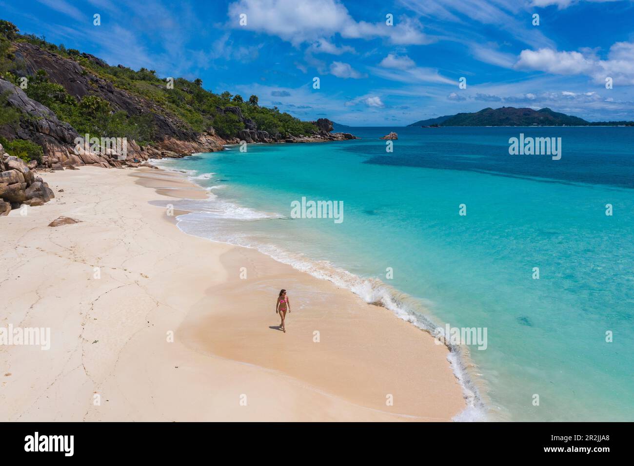 Aerial view of a young woman walking on Anse St Jose beach, Curieuse ...