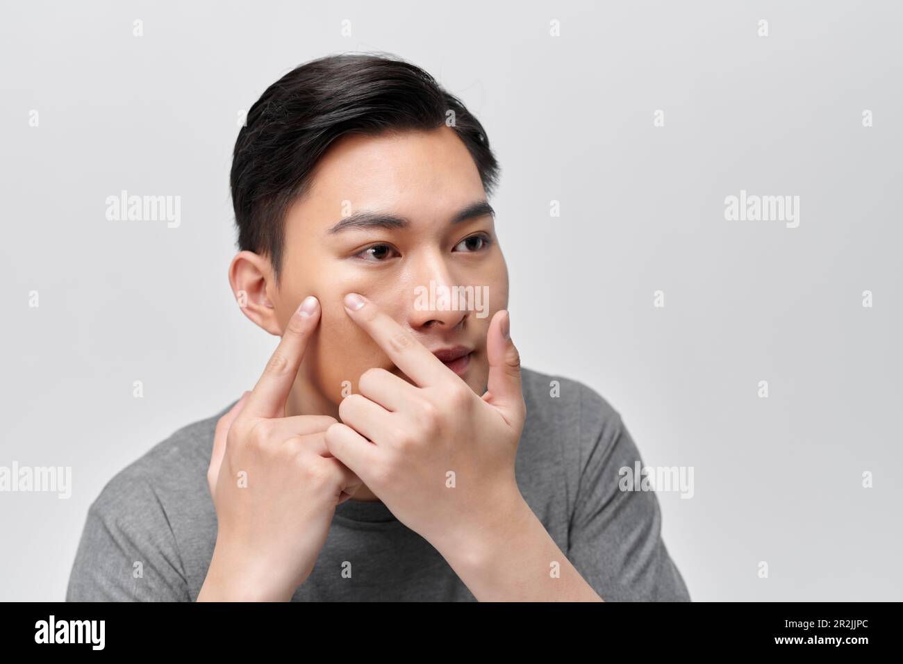 Handsome man touching his face. Squeezing pimple Stock Photo - Alamy