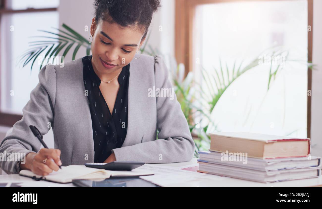 Business woman, calculator and writing in notebook on desk for finance ...