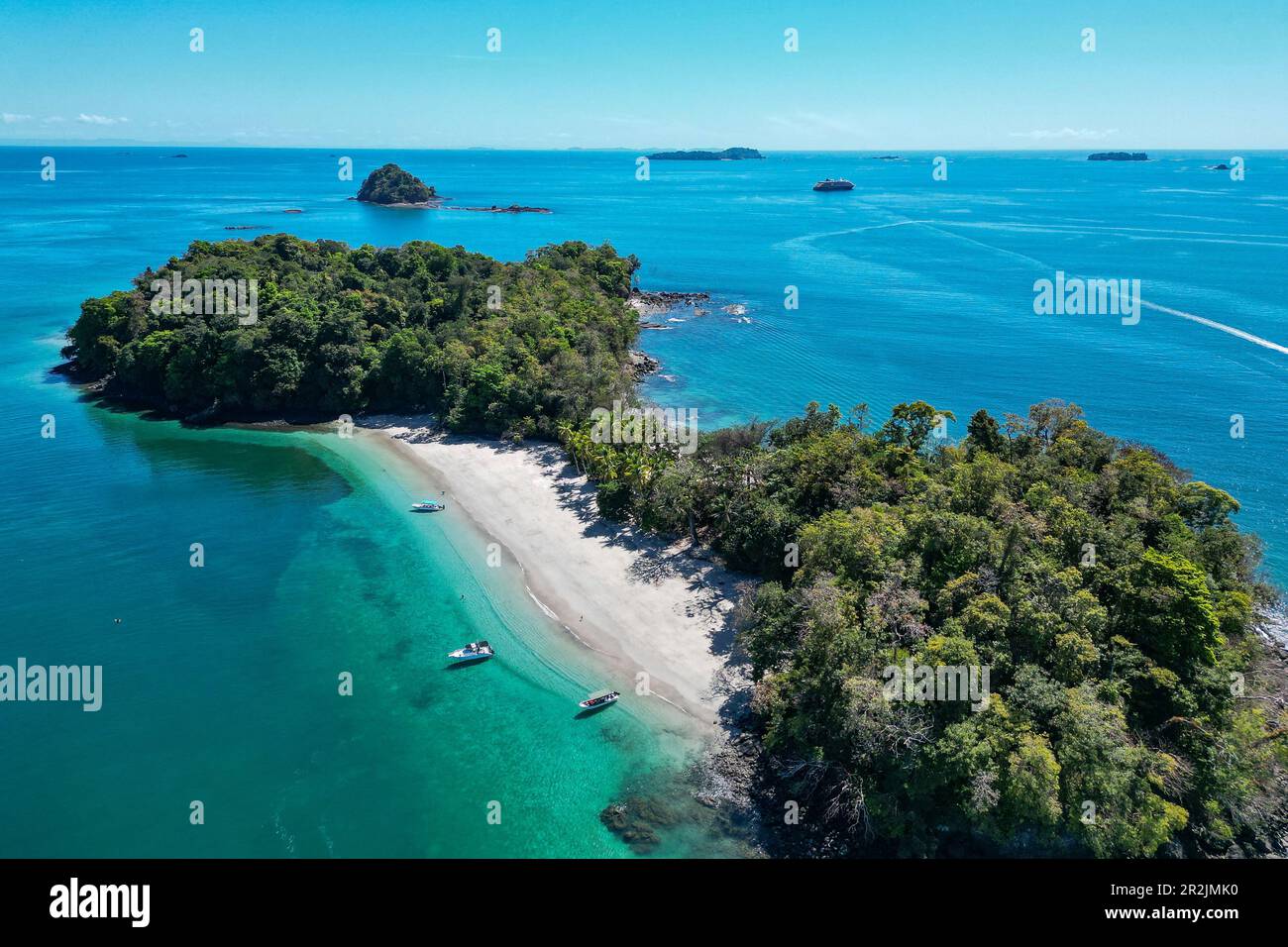 Aerial view of pristine beach on island with expedition cruise ship ...