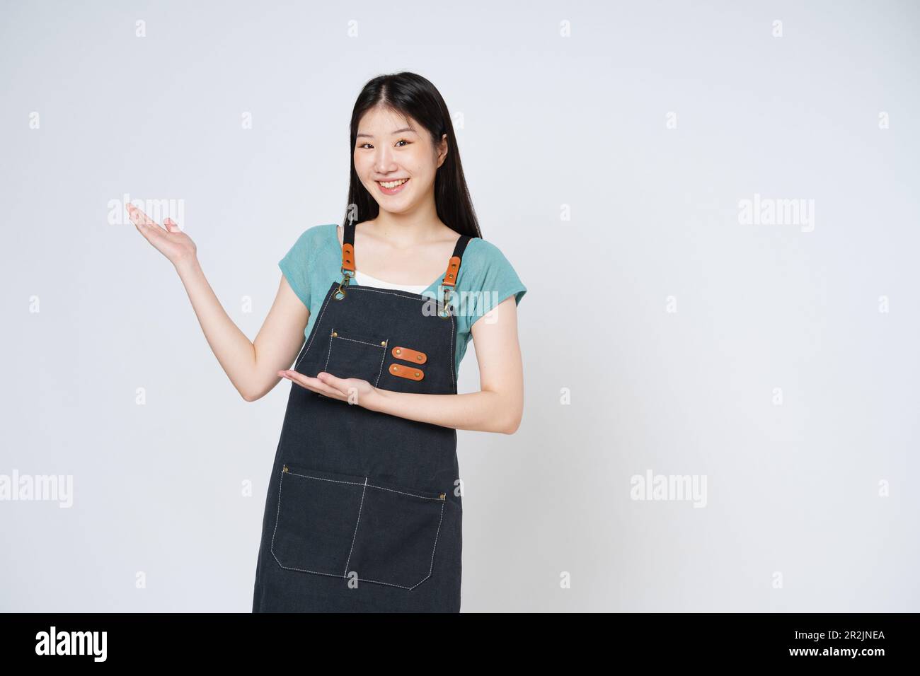 Happy smiling woman chef holding something on palm of hand over white ...