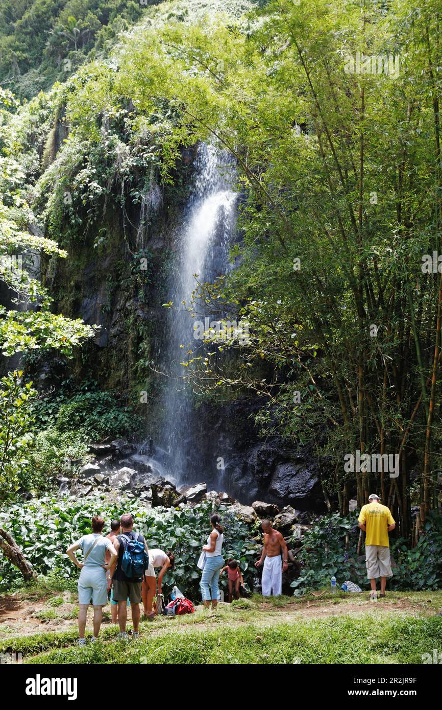 People in front of a waterfall at Anse des Cascade in Bois-Blanc, La ...