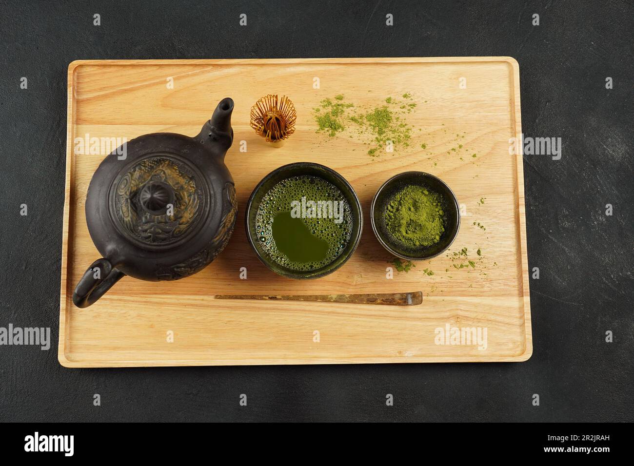 Green matcha tea powder with a bamboo whisk and scoop as used in a ...