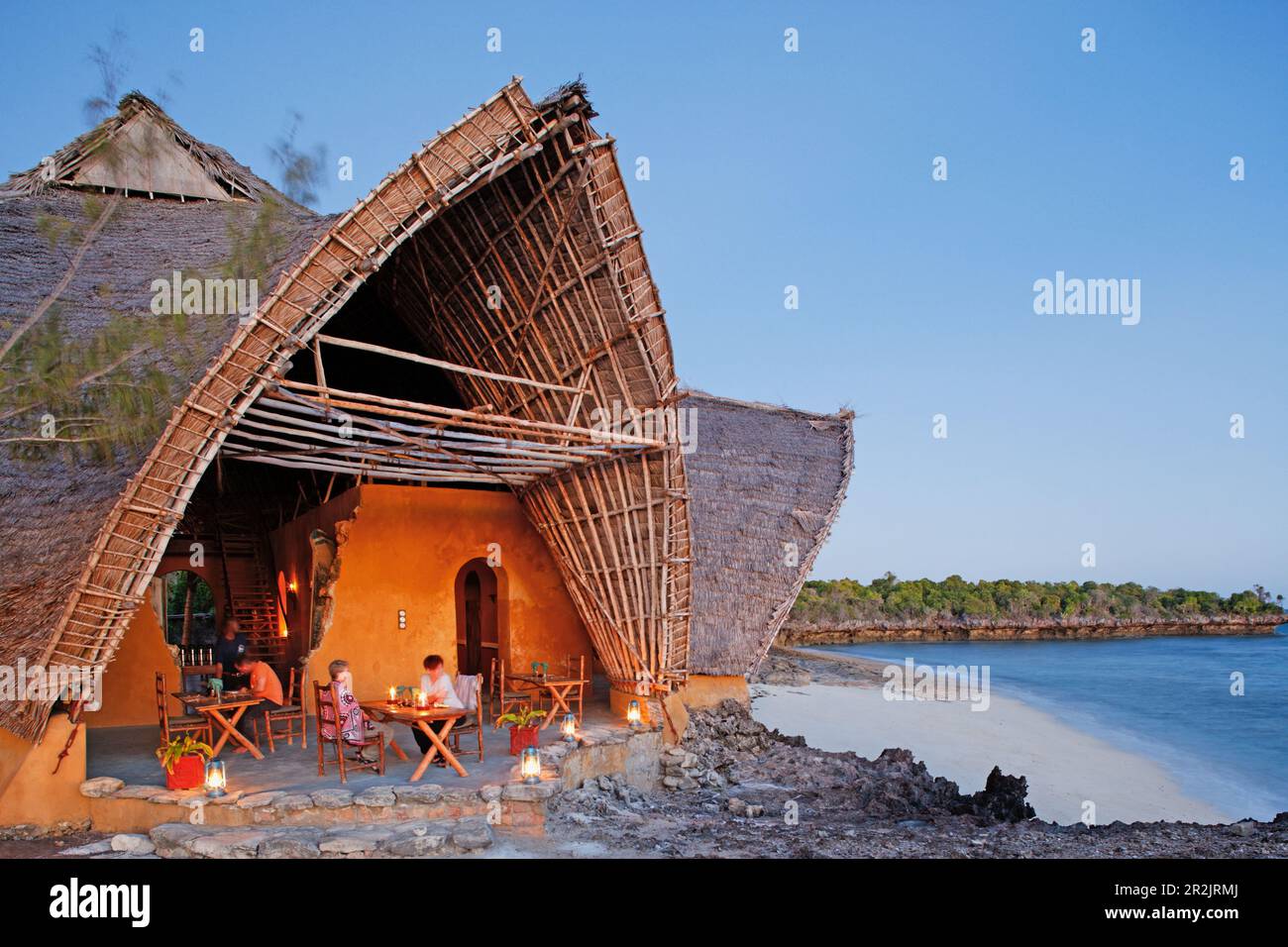 People in front of the Chumbe Island Coral Park Lodge at dusk ...