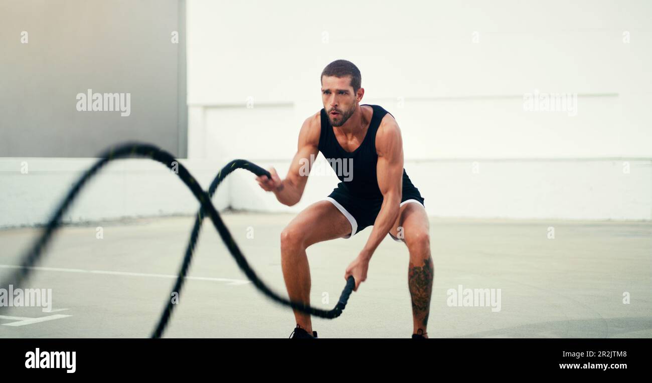 Man, fitness and battle rope exercise for physical training, workout or ...