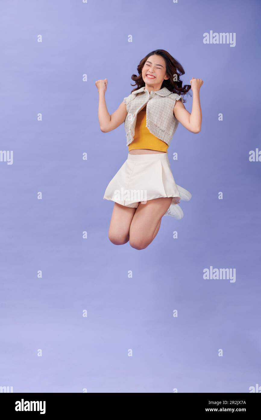 Photo of sweet lucky young woman jumping high rising arms smiling Stock ...