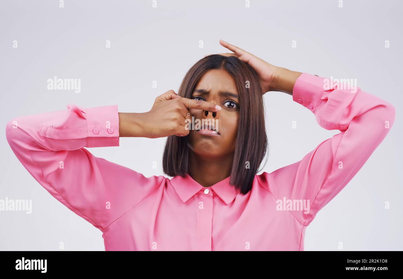 Portrait, funny face and nose with an indian woman in studio on a gray ...