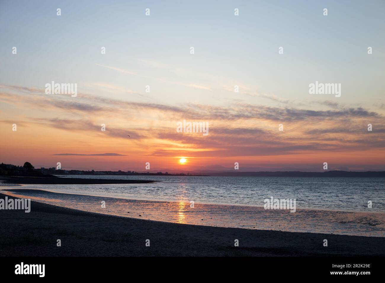Sunset over Edinburgh as seen from Musselburgh beach on a sunny spring ...