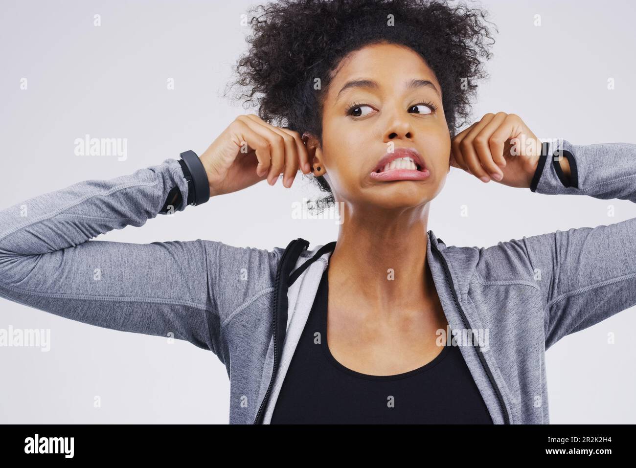 Funny face, pulling ears and an african woman in studio on a gray ...