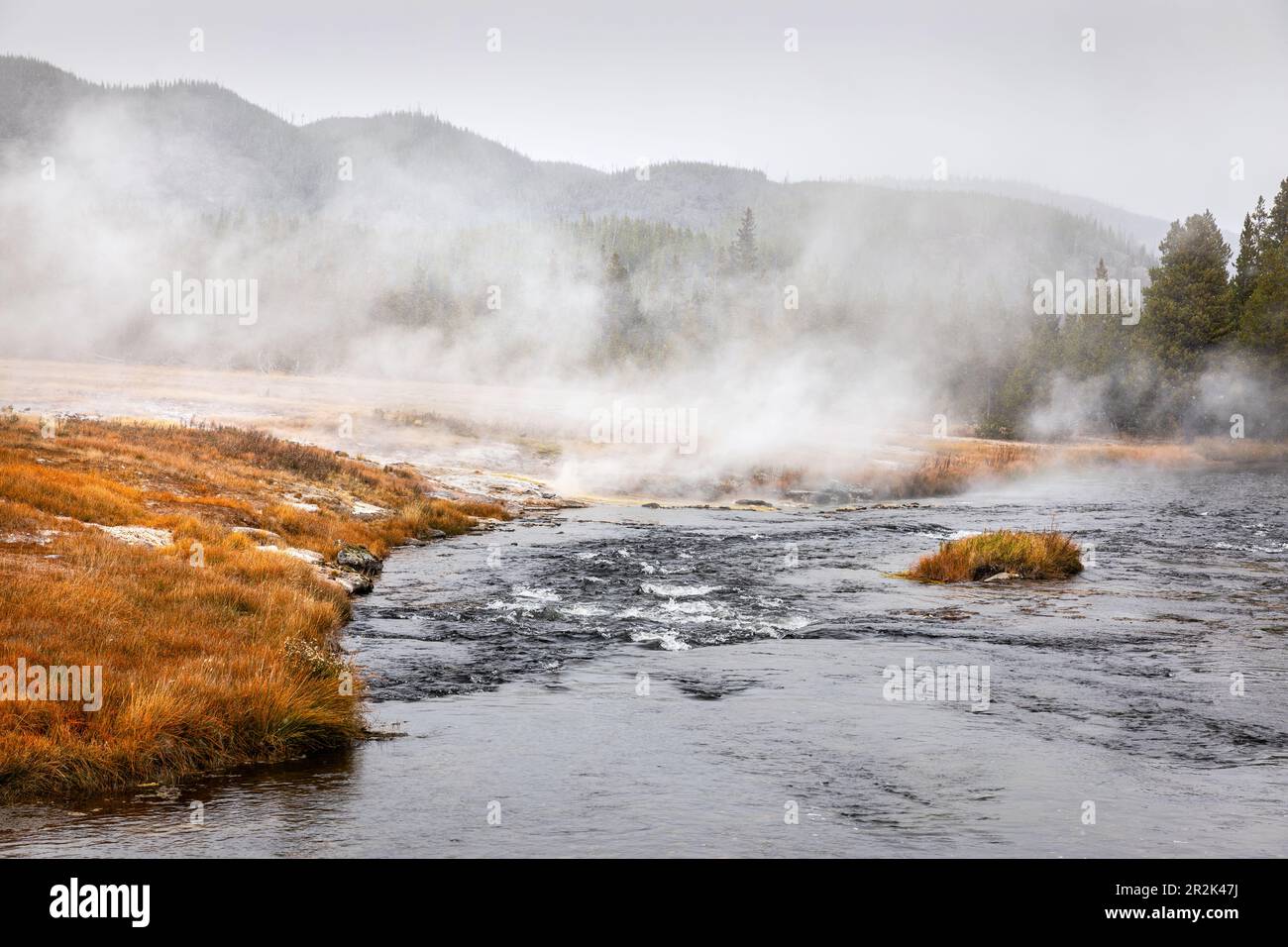 Natural scene of boiling flowing water from geyser basin with white ...