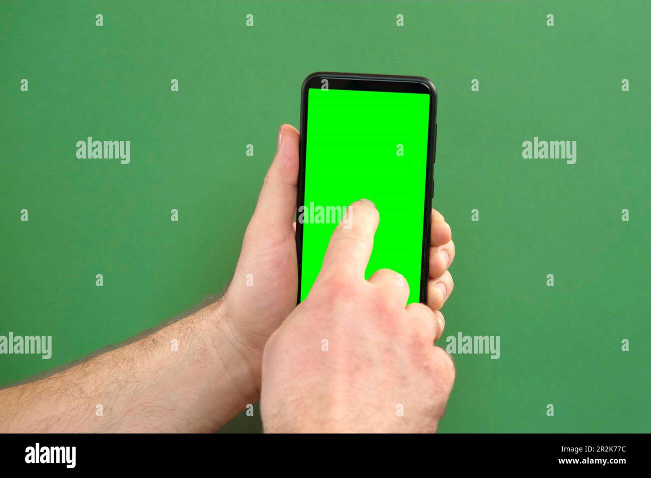 Young Man Hand Use Smartphone With Green Screen On Green Background