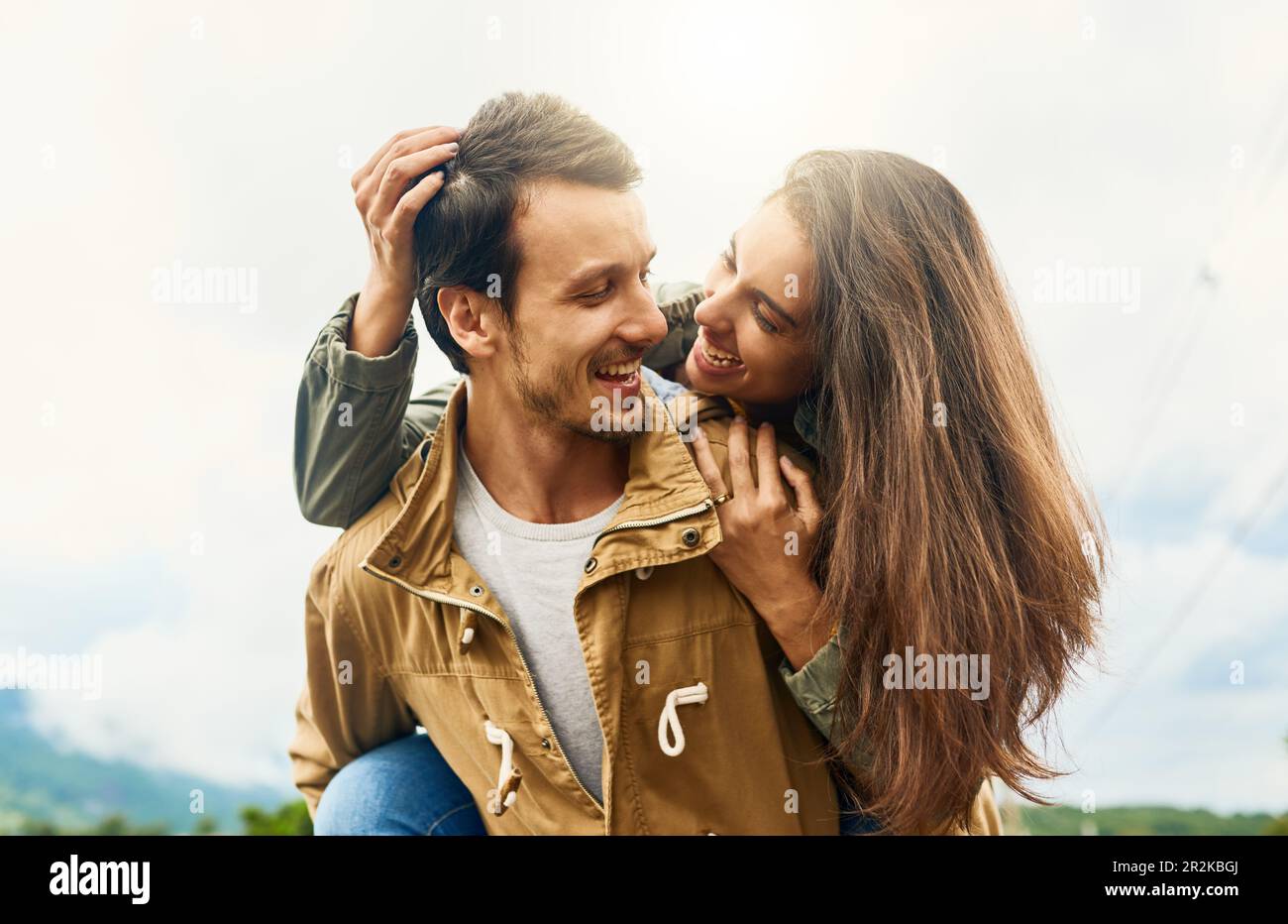 Playful, love and piggyback with couple in nature for weekend, smile ...