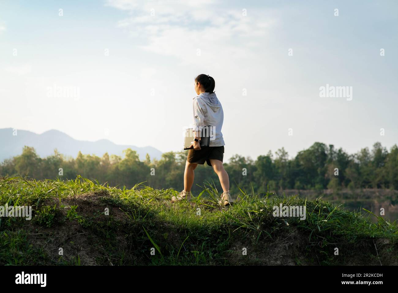 Female environmentalist using laptop computer to record natural water ...