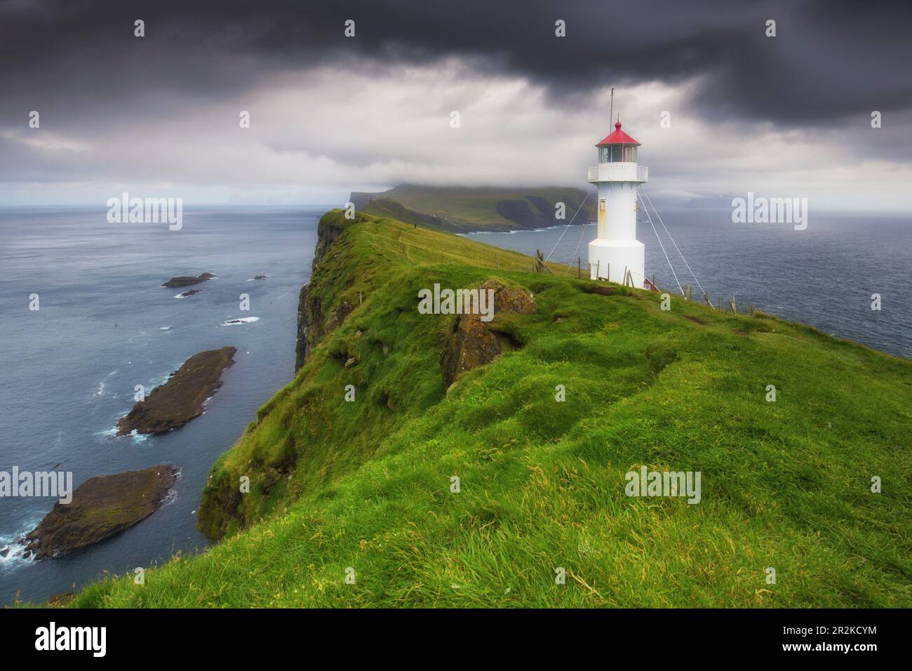 View of cliffs and Mykines Holmur Lighthouse up to Mykines, Faeroe ...