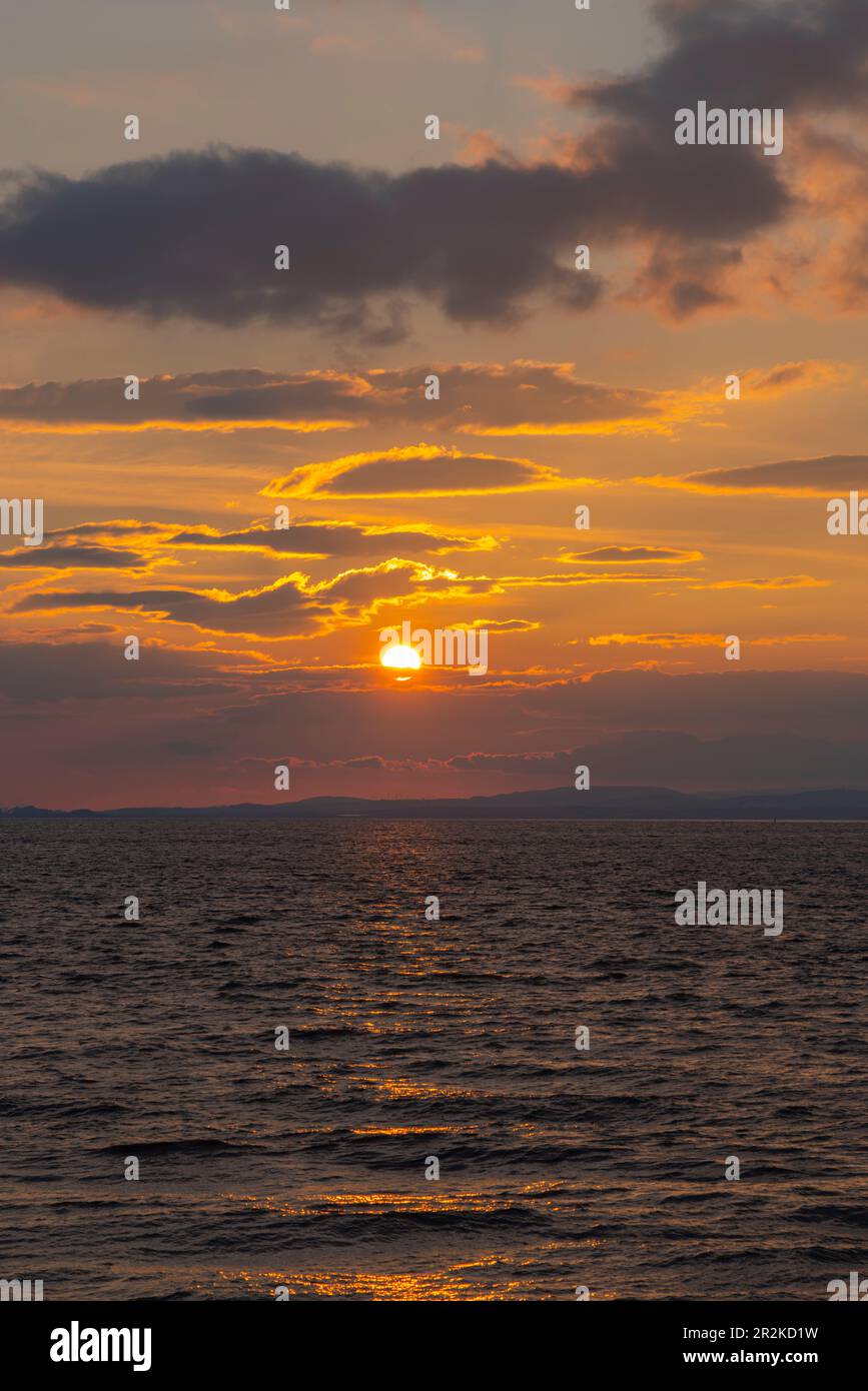 The setting sun lighting up the cloud cover Stock Photo - Alamy