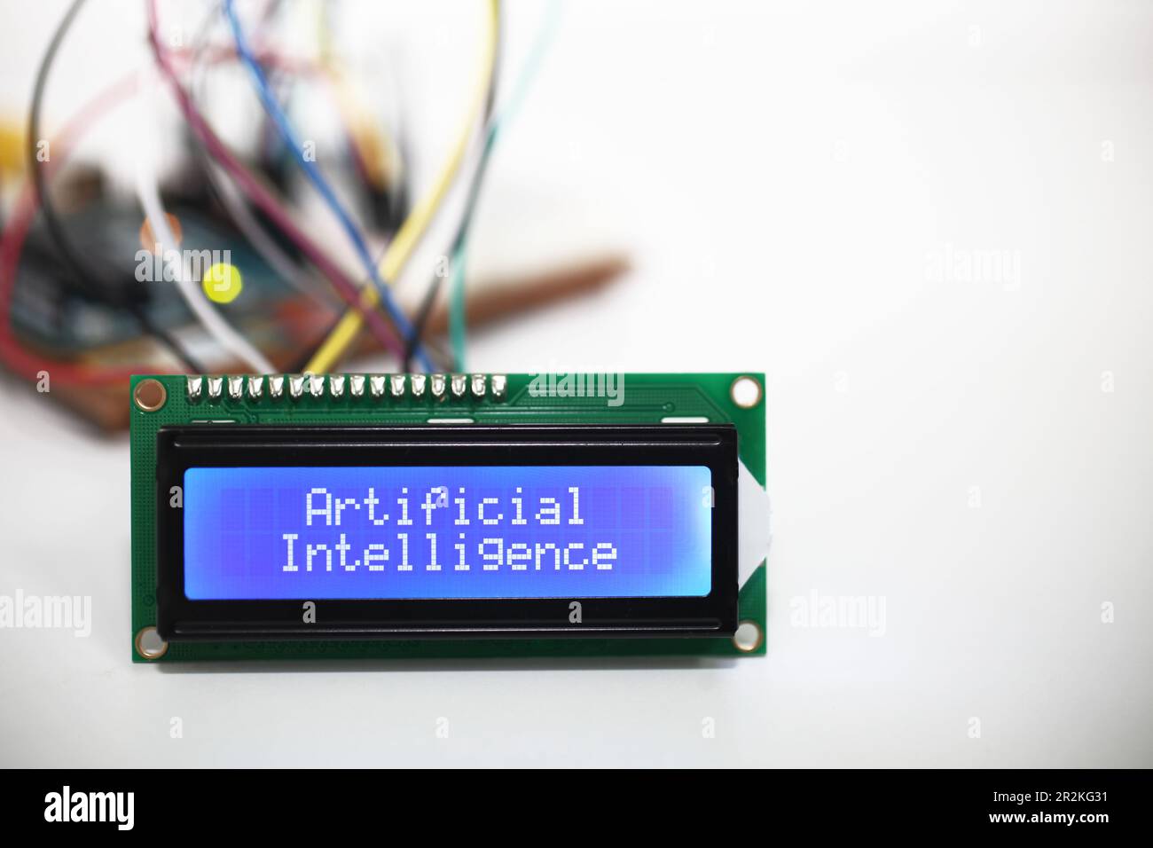 Blue LCD display showing the words 'Artificial Intelligence'. Wires ...