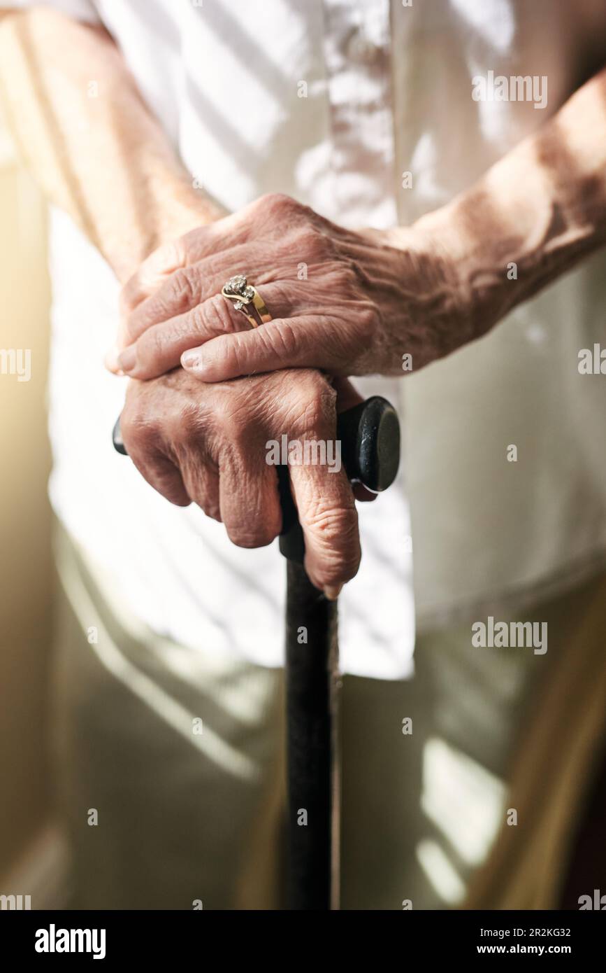 Hands, walking stick and closeup with elderly woman, injury and mobility with balance in ...