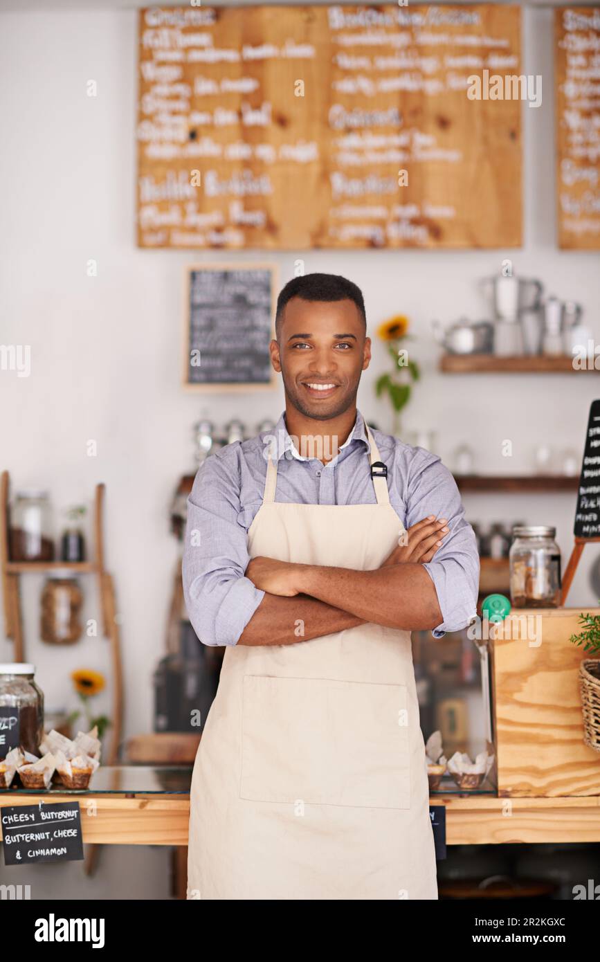 Black man, portrait smile and waiter with arms crossed in cafe with ...