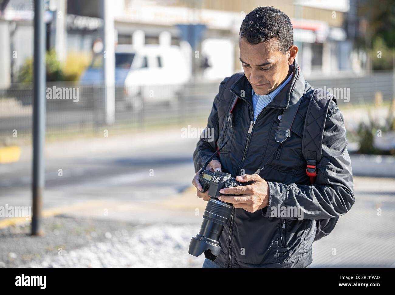 Photographer reviewing the photographs on his camera on the street ...