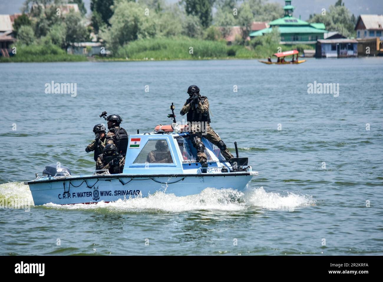 Srinagar, India. 20th May, 2023. Indian paramilitary troopers take position in a motorboat as ...