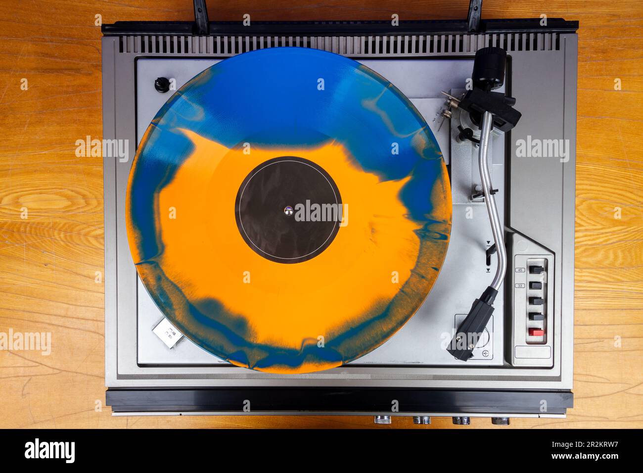 Vintage turntable vinyl record player with blue and orange vinyl on a ...