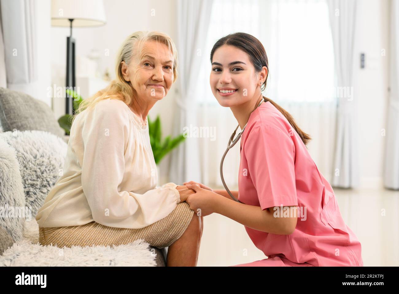 Happy doctor talking with elderly patient at home visit Stock Photo - Alamy