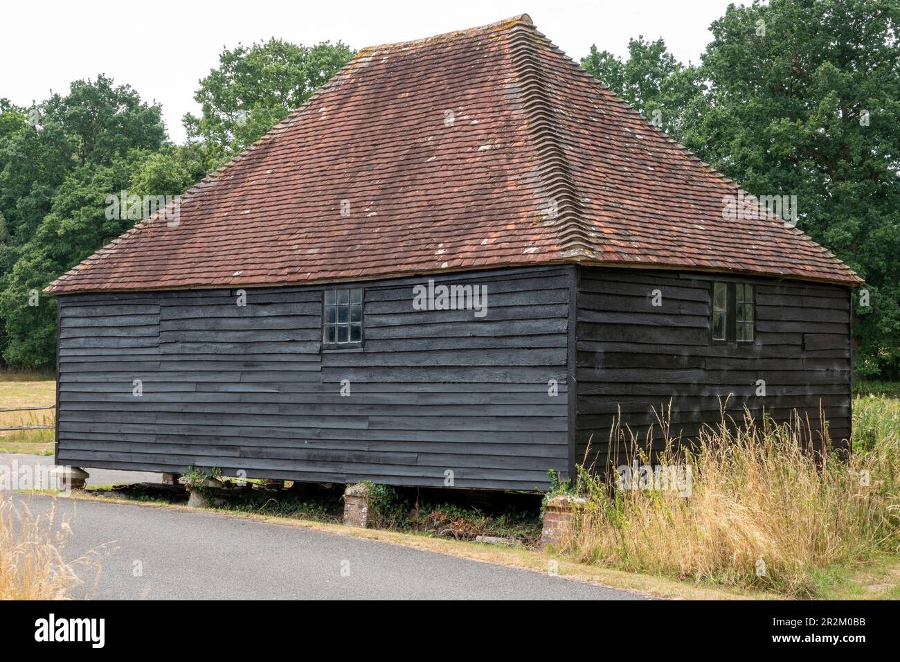 Black timber, tiled roof, Sussex barn mounted on staddle stones Stock ...