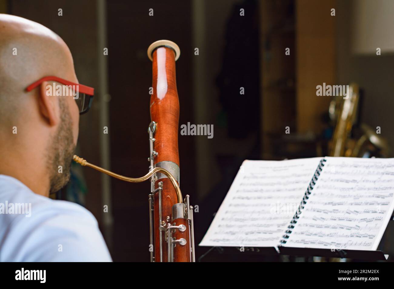 rear view of bassoonist man, studying and practicing music, he is ...