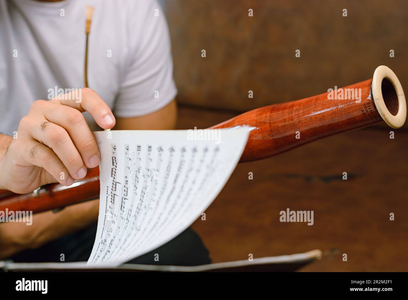closeup of bassoonist male hand turning sheet music page on music stand ...