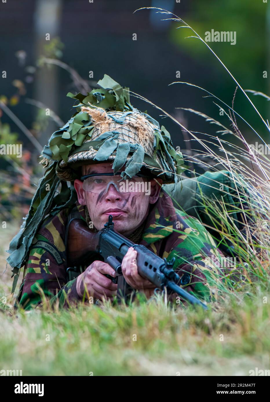 1970 British Army soldier in camouflage suit and steel helmet carrying ...