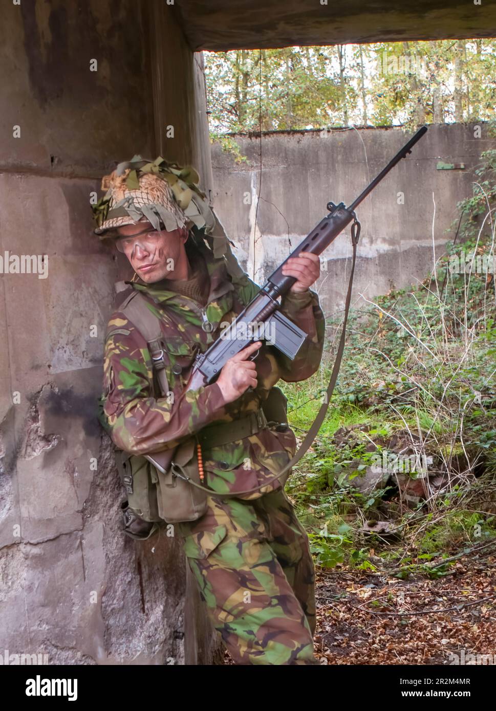 1970 British Army soldier in camouflage suit and steel helmet carrying ...