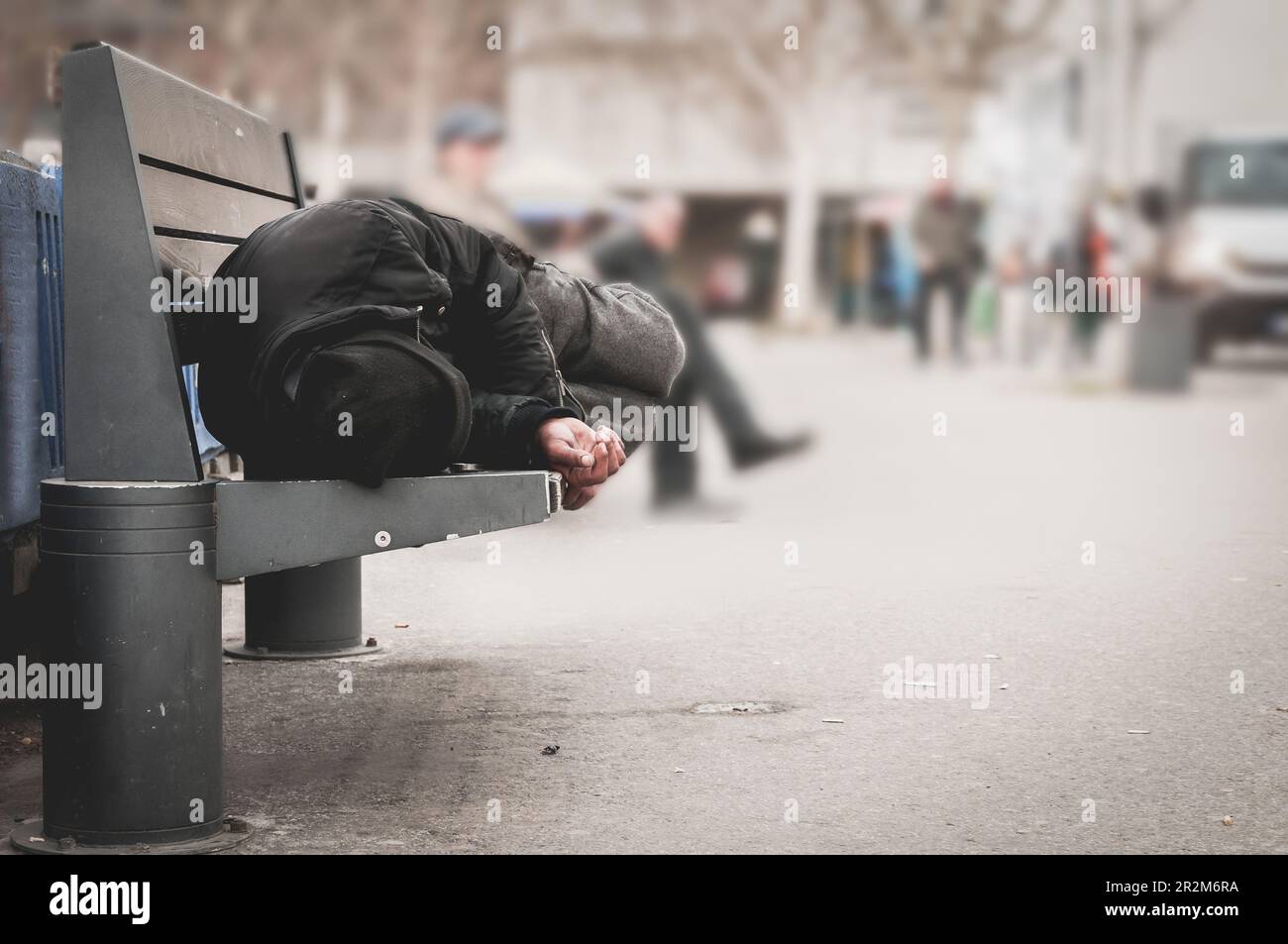 Poor tired depressed hungry homeless man or refugee sleeping on the ...