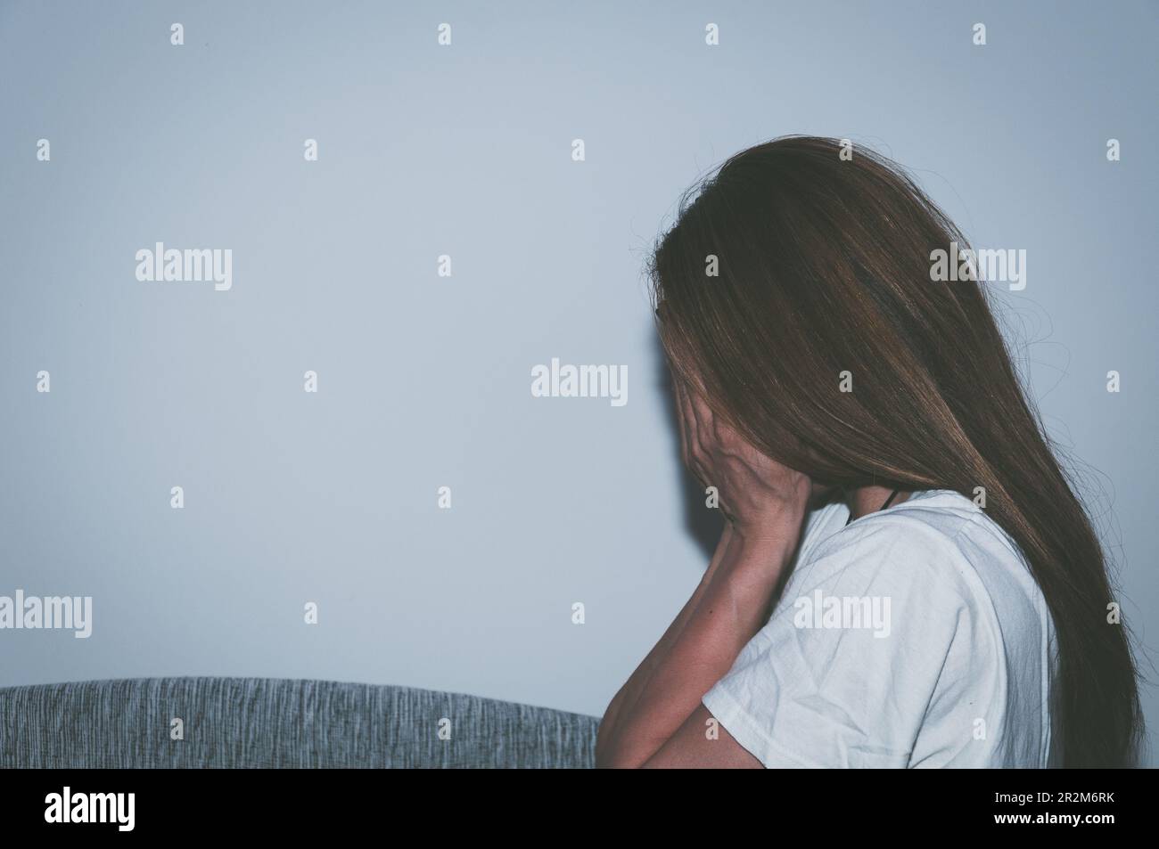 Lonely young woman feeling depressed and stressed sitting head in hands ...