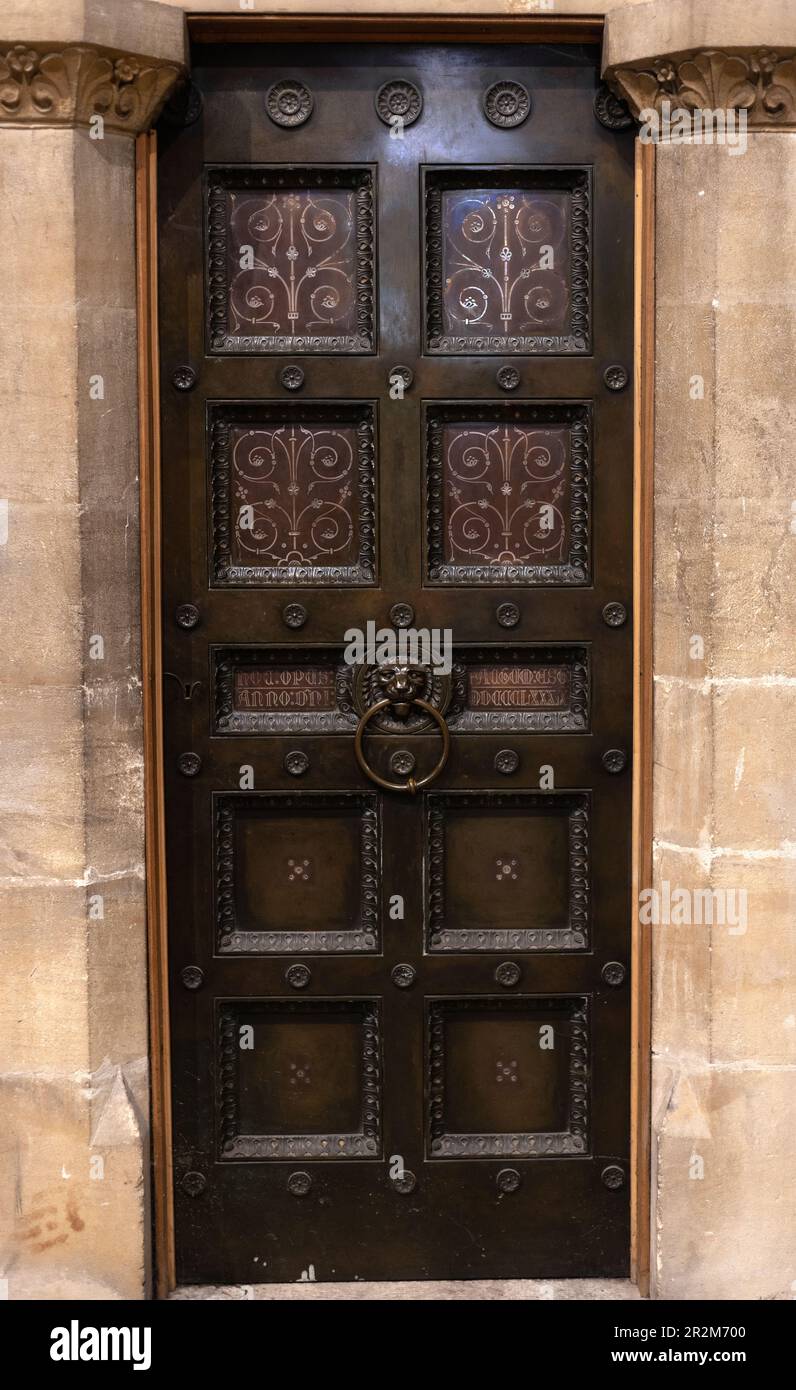 A large, ornate wooden door with a metal pull handle, inside Saint Fin ...