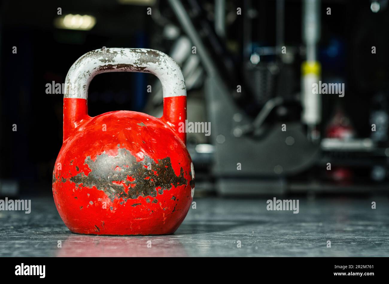 Old used red kettlebell on the gym floor ready for crossfit strength ...