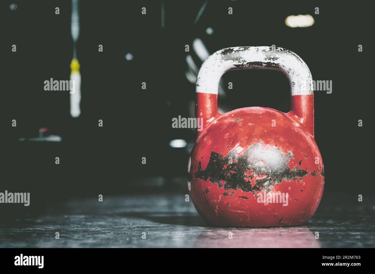 Old used red kettlebell on the gym floor ready for crossfit strength ...