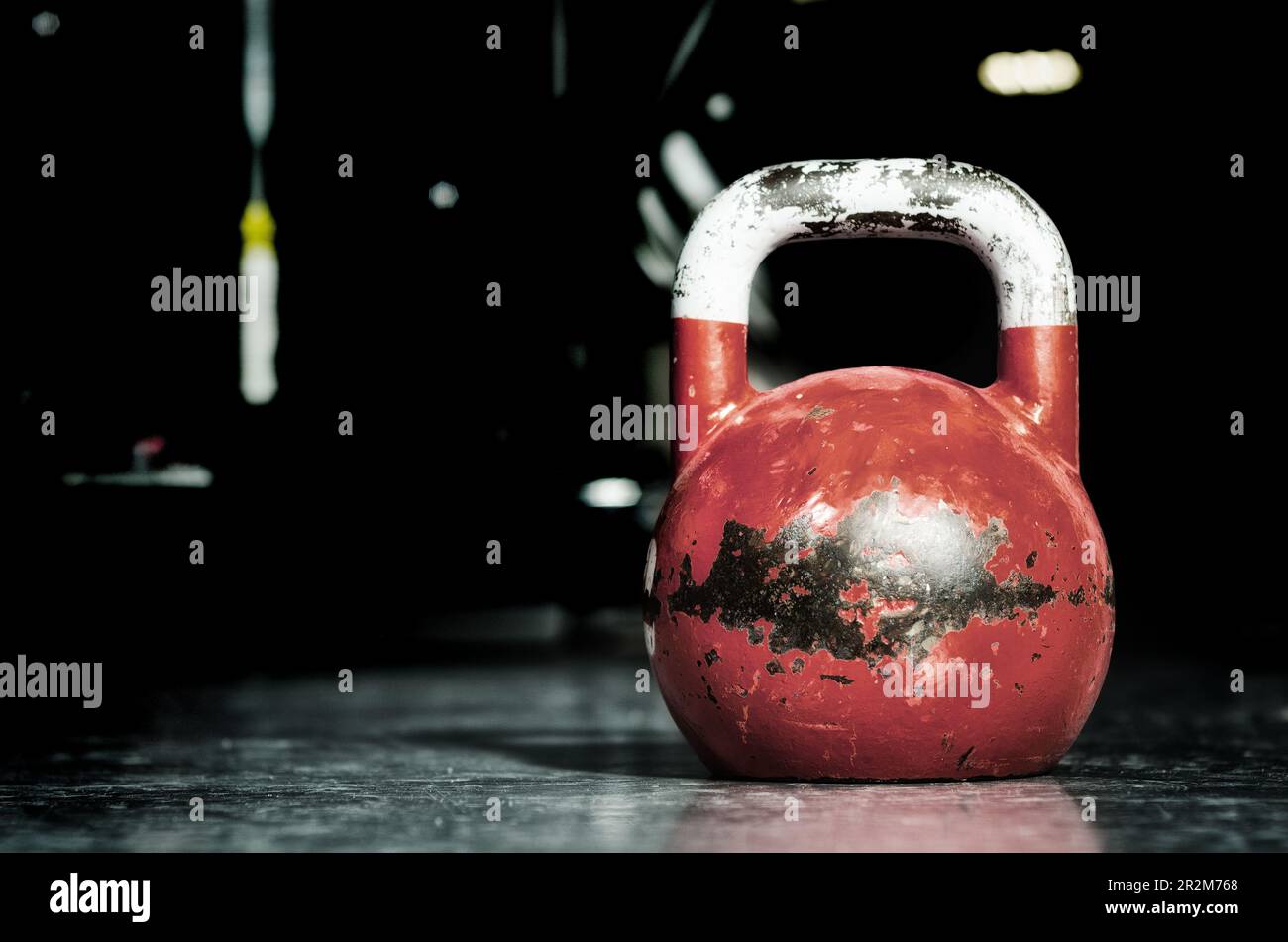 Old used red kettlebell on the gym floor ready for crossfit strength ...