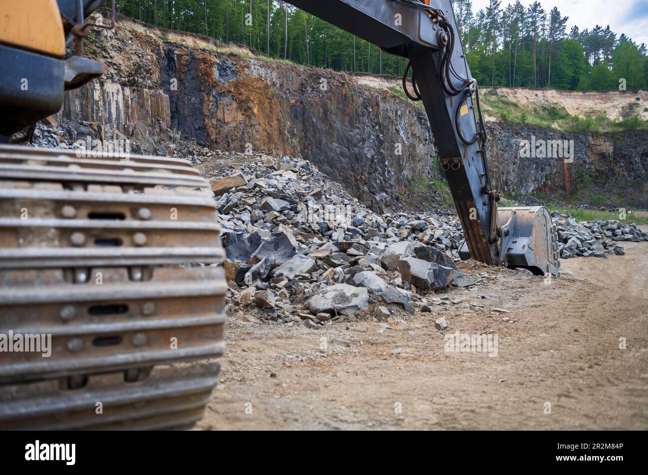 Excavator bucket at basalt quarry. Basalt mining. Excavators in a ...