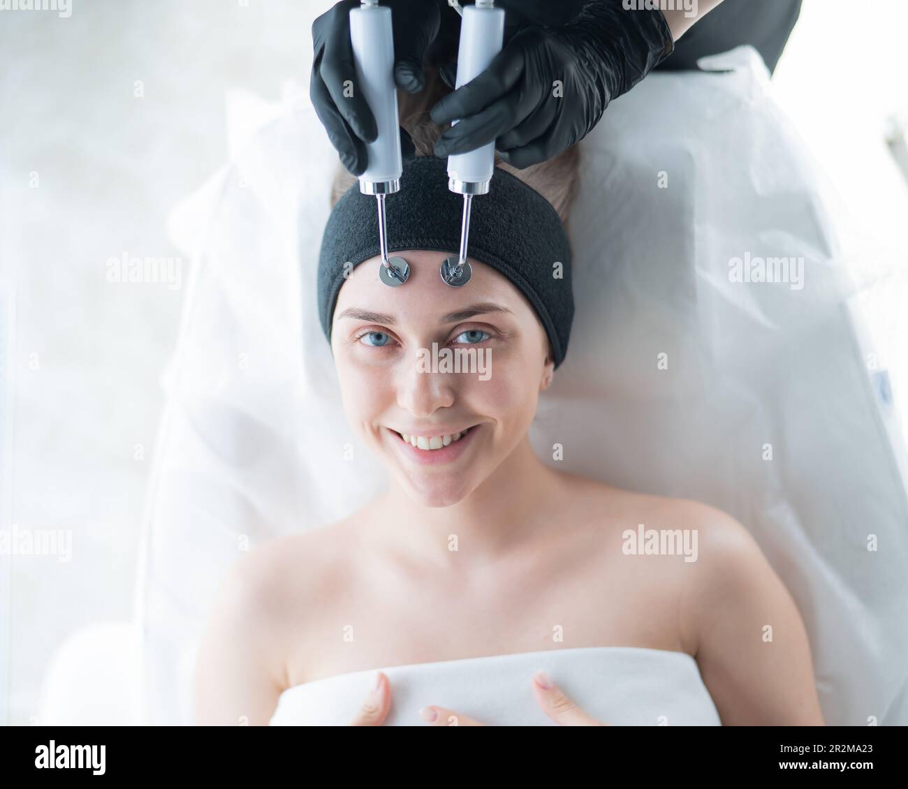 Young caucasian woman on microcurrent therapy procedure. Beautician's ...
