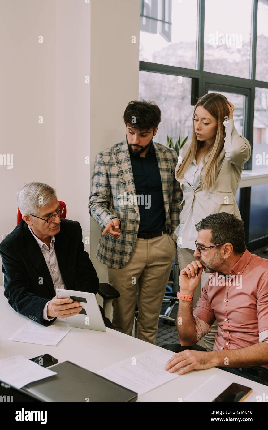 Problem solving at the office. Four coworkers working on their daily ...