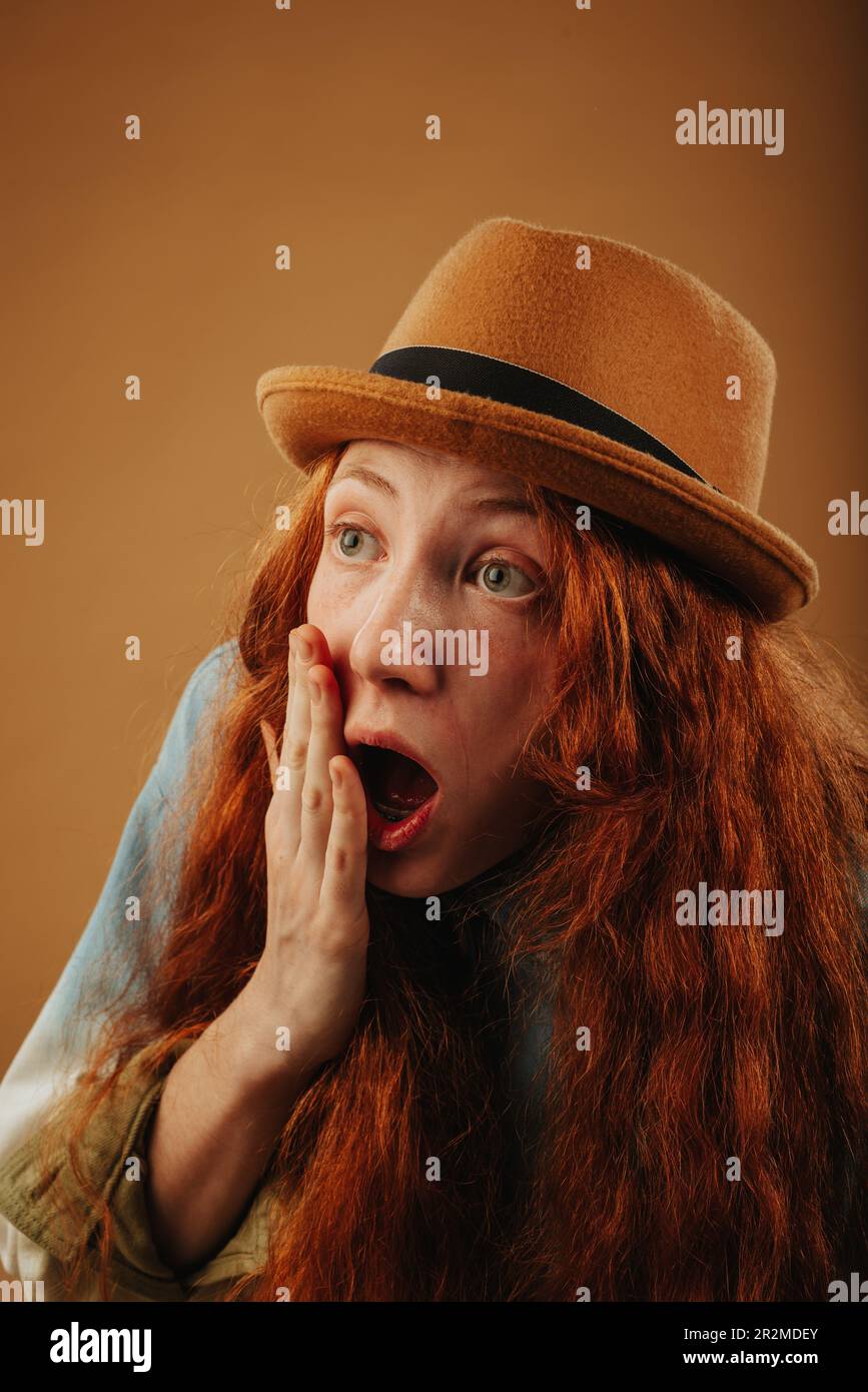 Close up of ginger girl acting suprised while posing at the studio ...