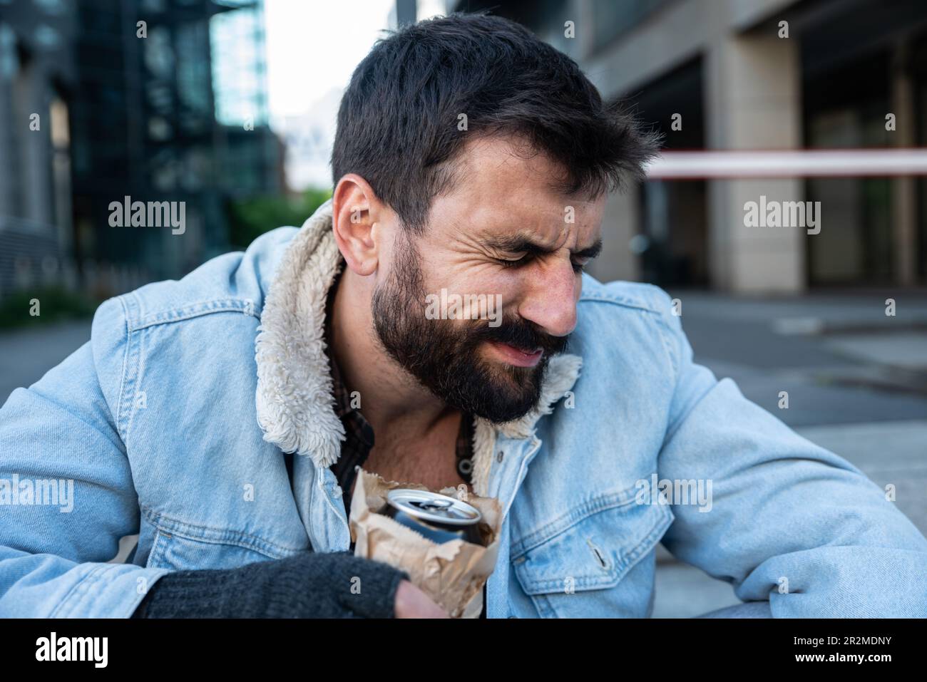 Young sad sick poor homeless man sitting on the street need help ...