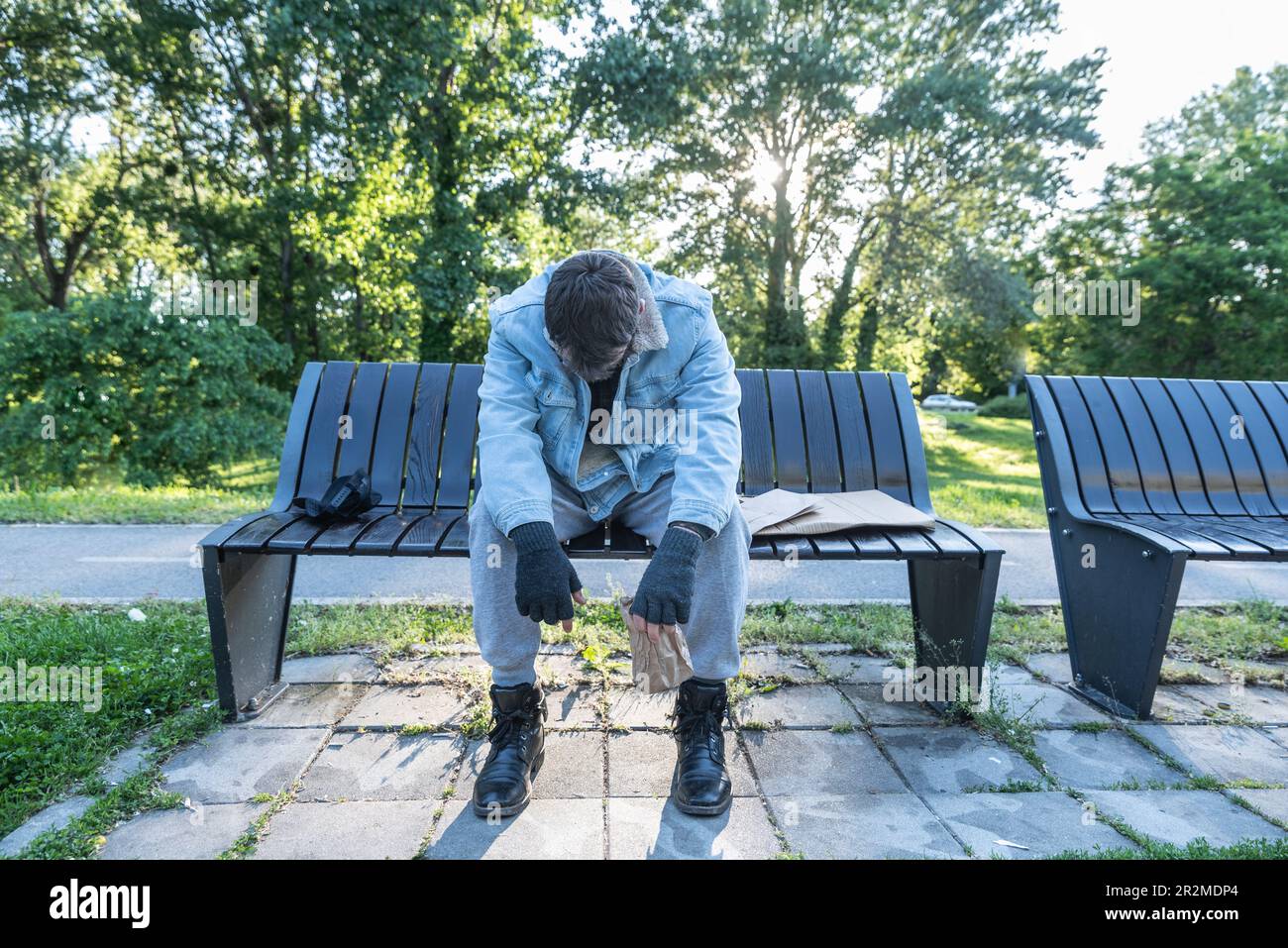 Young sad sick poor homeless man sitting on the street need help ...
