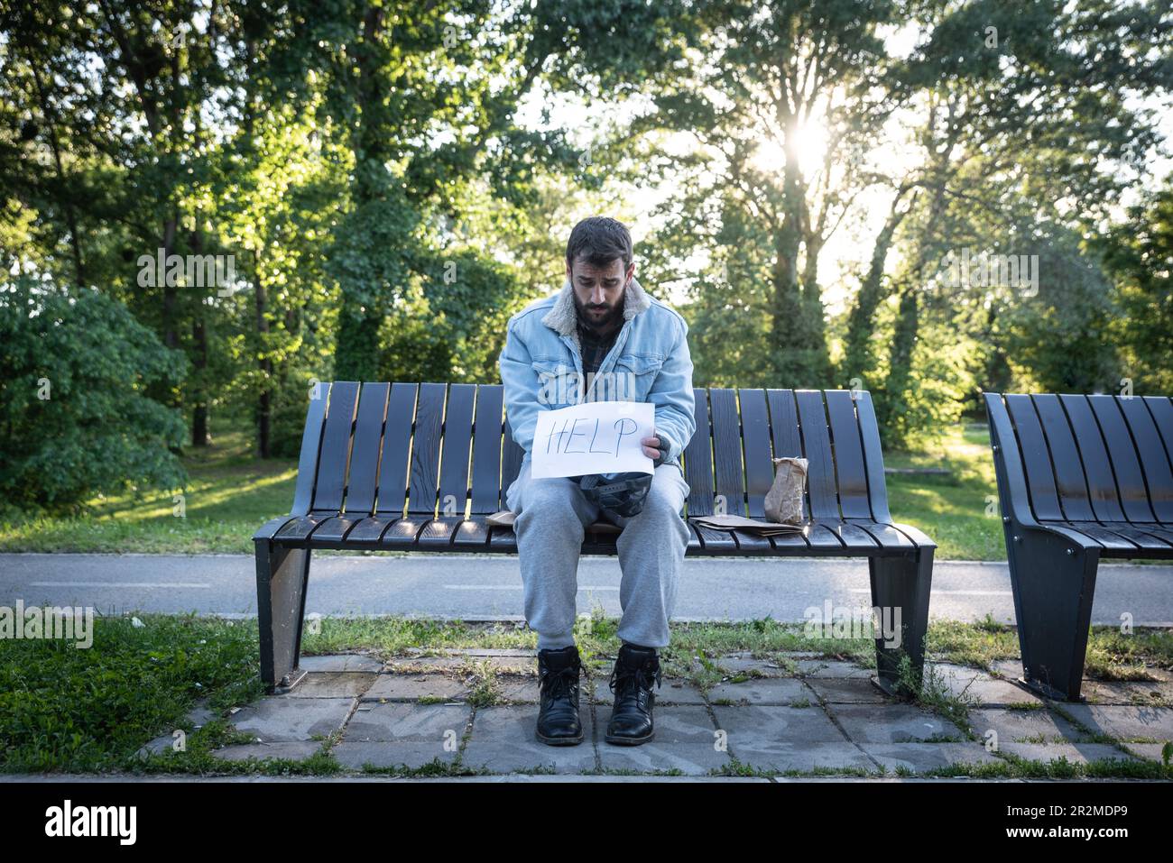 Young sad sick poor homeless man sitting on the street need help ...