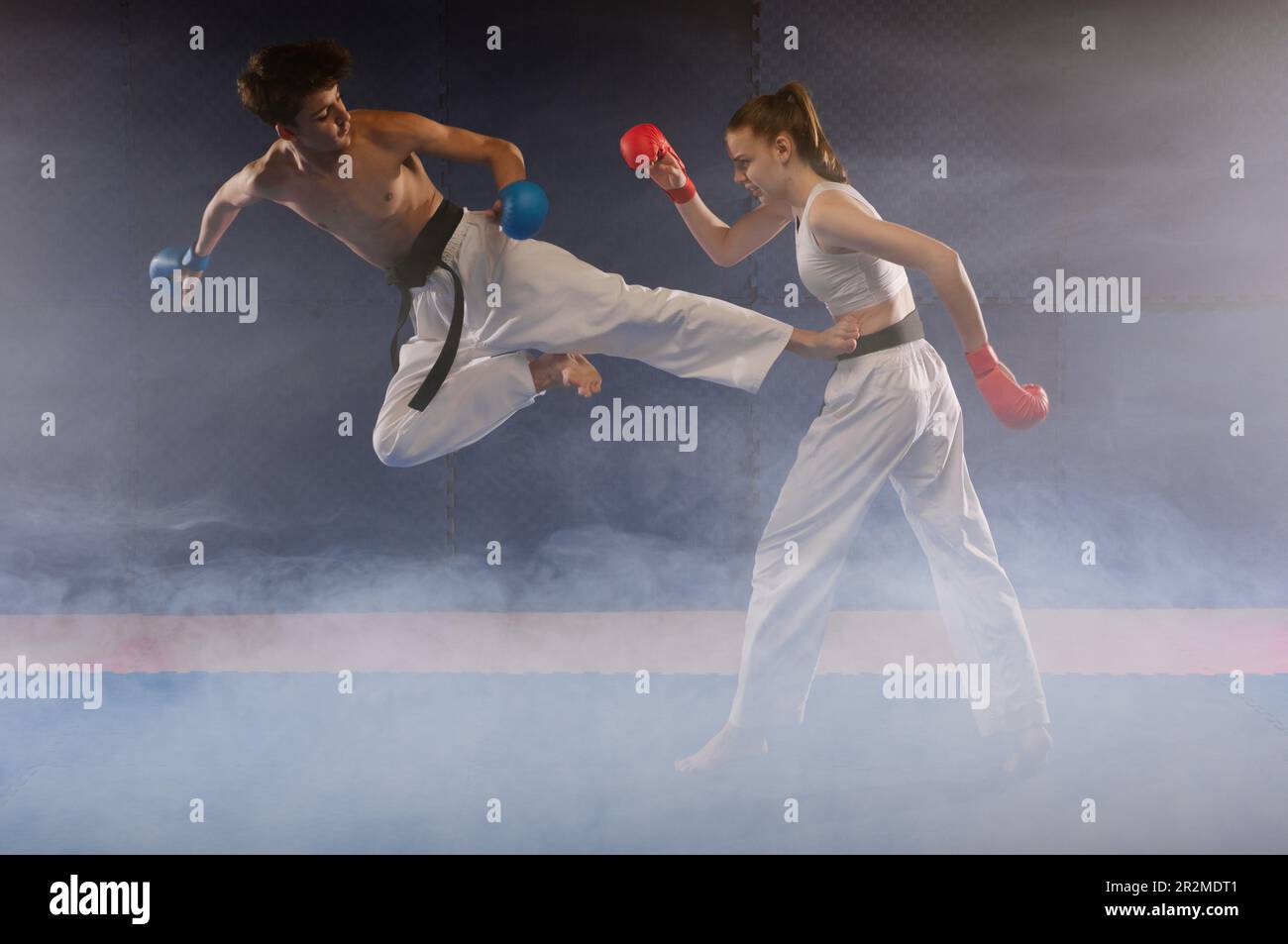 Close up of two young karate friends doing the Ushiro Tobi Geri at the ...