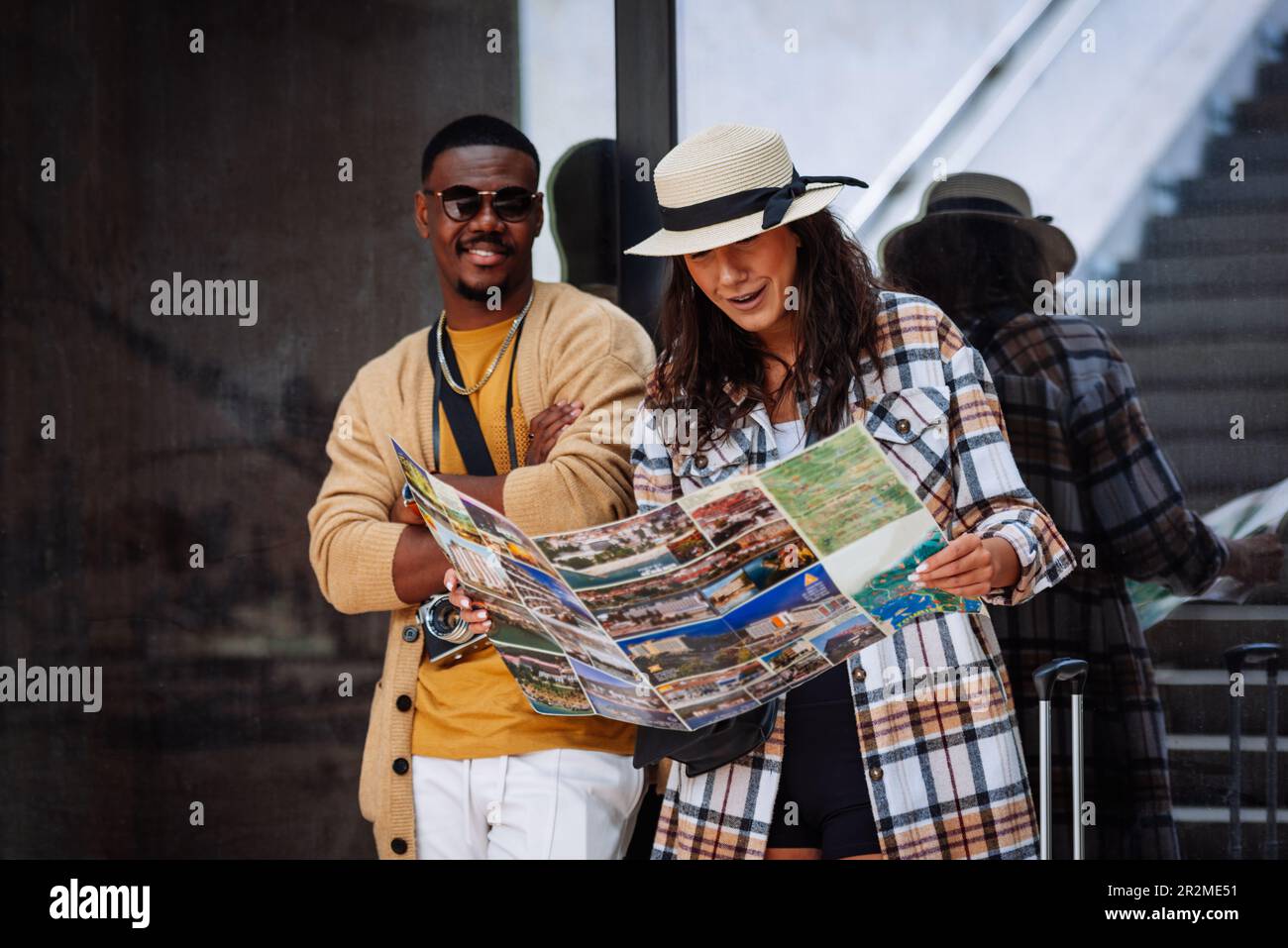 A multiracial couple are visiting a city. Looking for attractions on ...