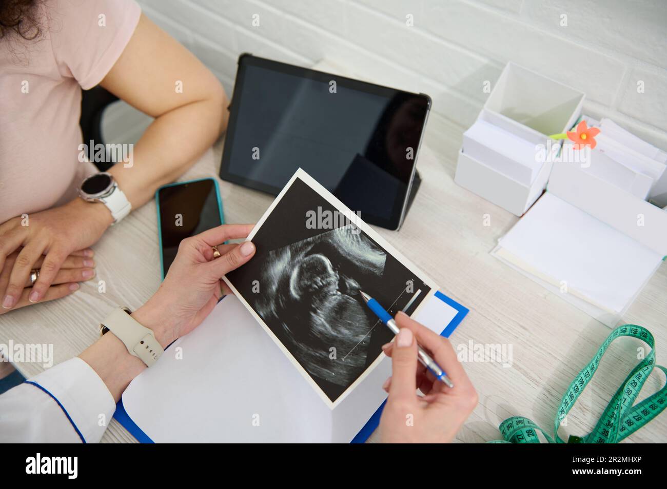 Top view hands of gynecologist doctor explaining to pregnant woman the ...