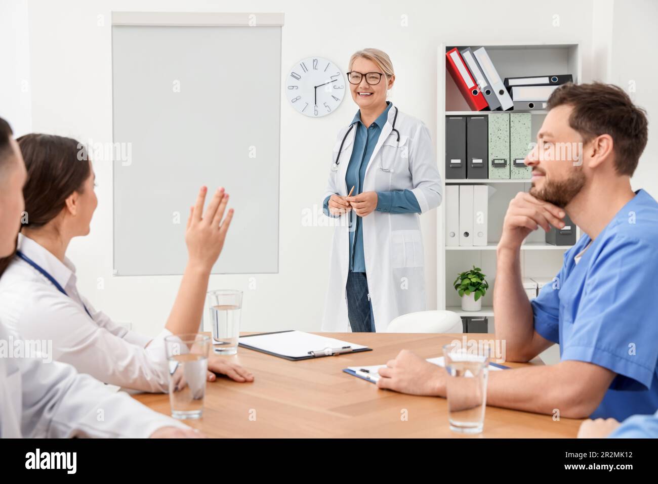 Doctor giving lecture near flipchart in conference room Stock Photo - Alamy
