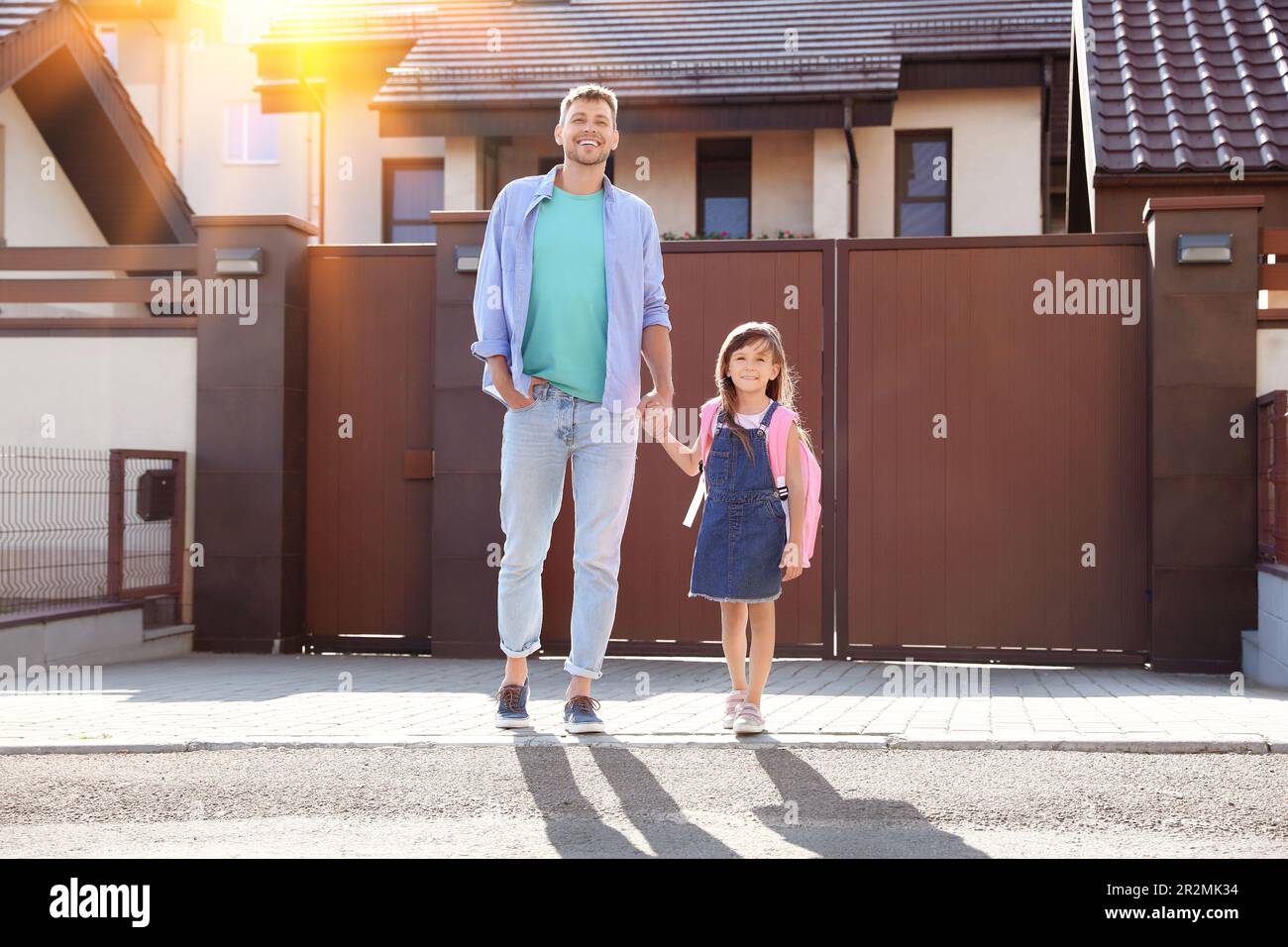 Happy father taking his little child to school on street Stock Photo ...