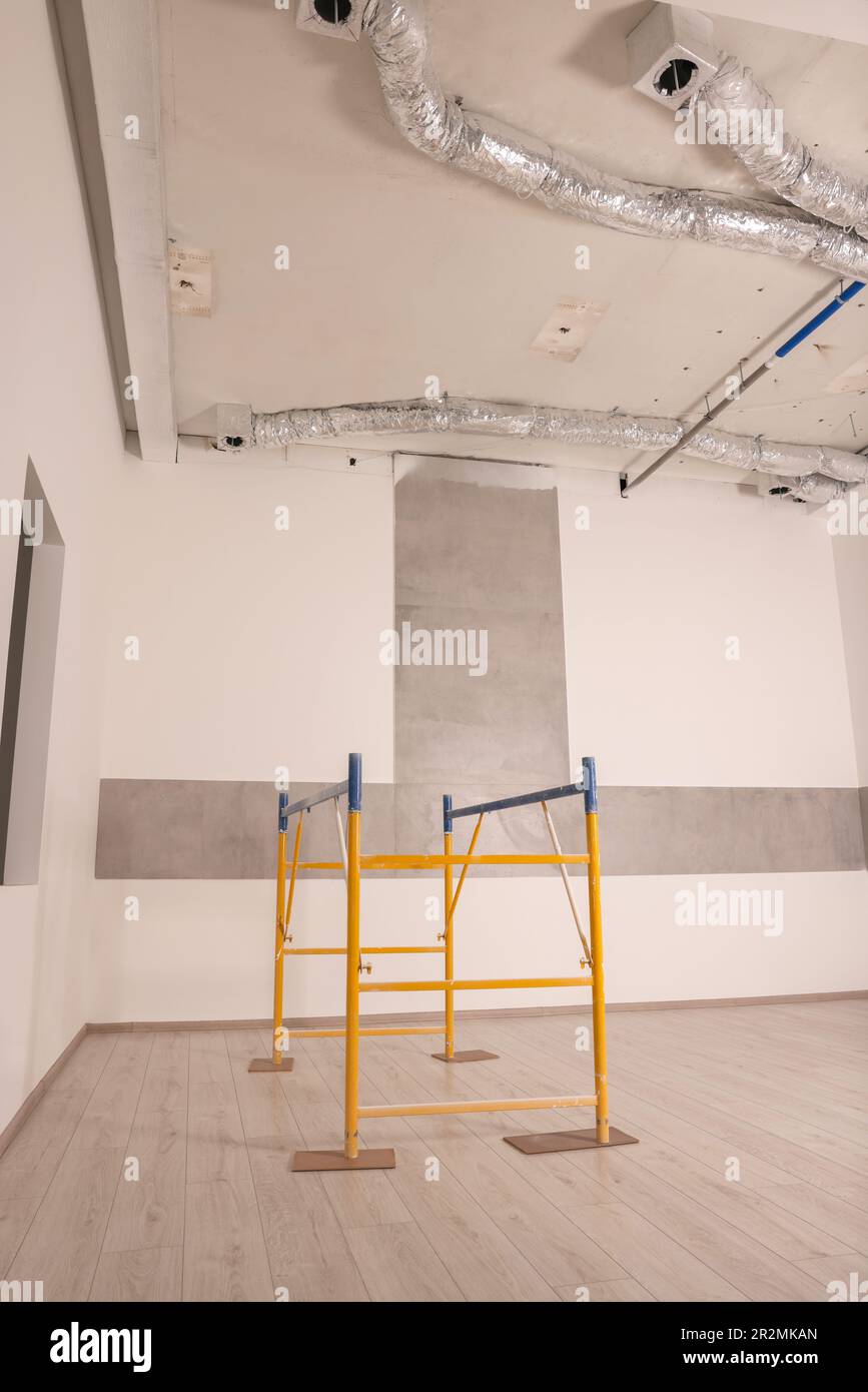 Professional construction scaffold in empty renovated room Stock Photo - Alamy